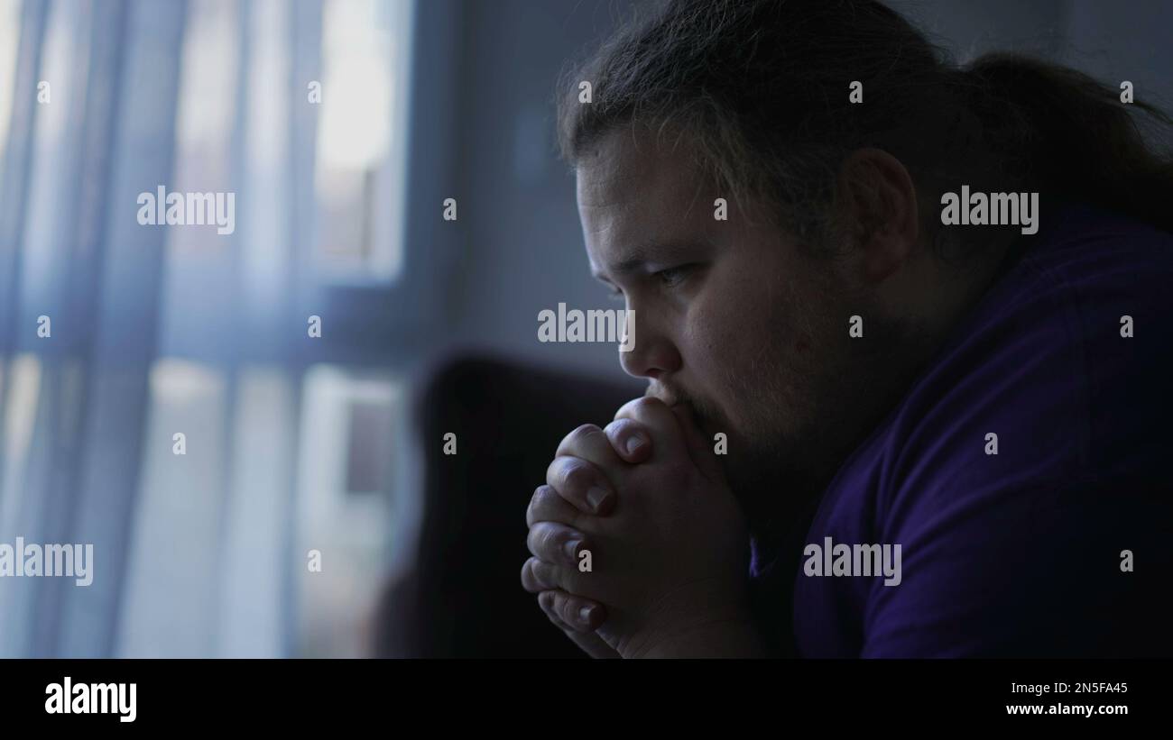 One worried overweight man at home with preoccupied expression. Profile ...