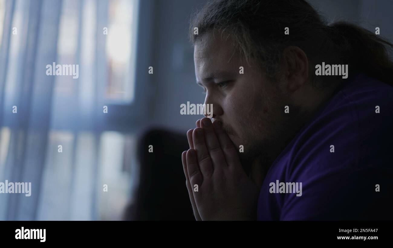 One worried overweight man at home with preoccupied expression. Profile ...
