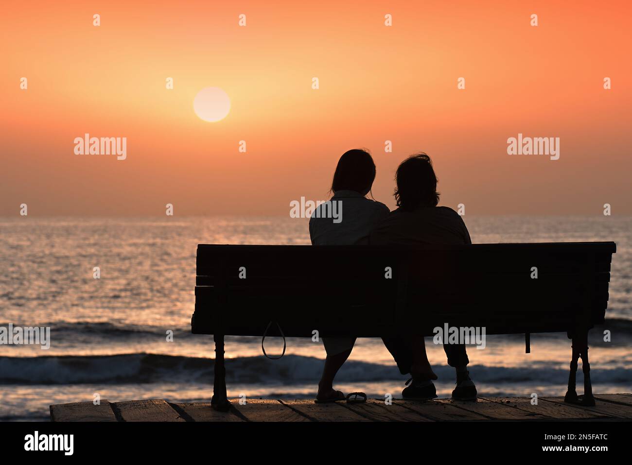 Back view of a couple silhouette, watching sunset on the beach Stock ...