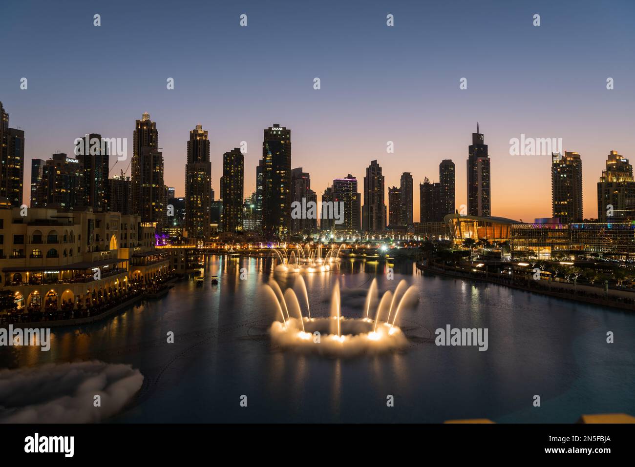 Dubai singing fountains at night lake view between skyscrapers. City ...