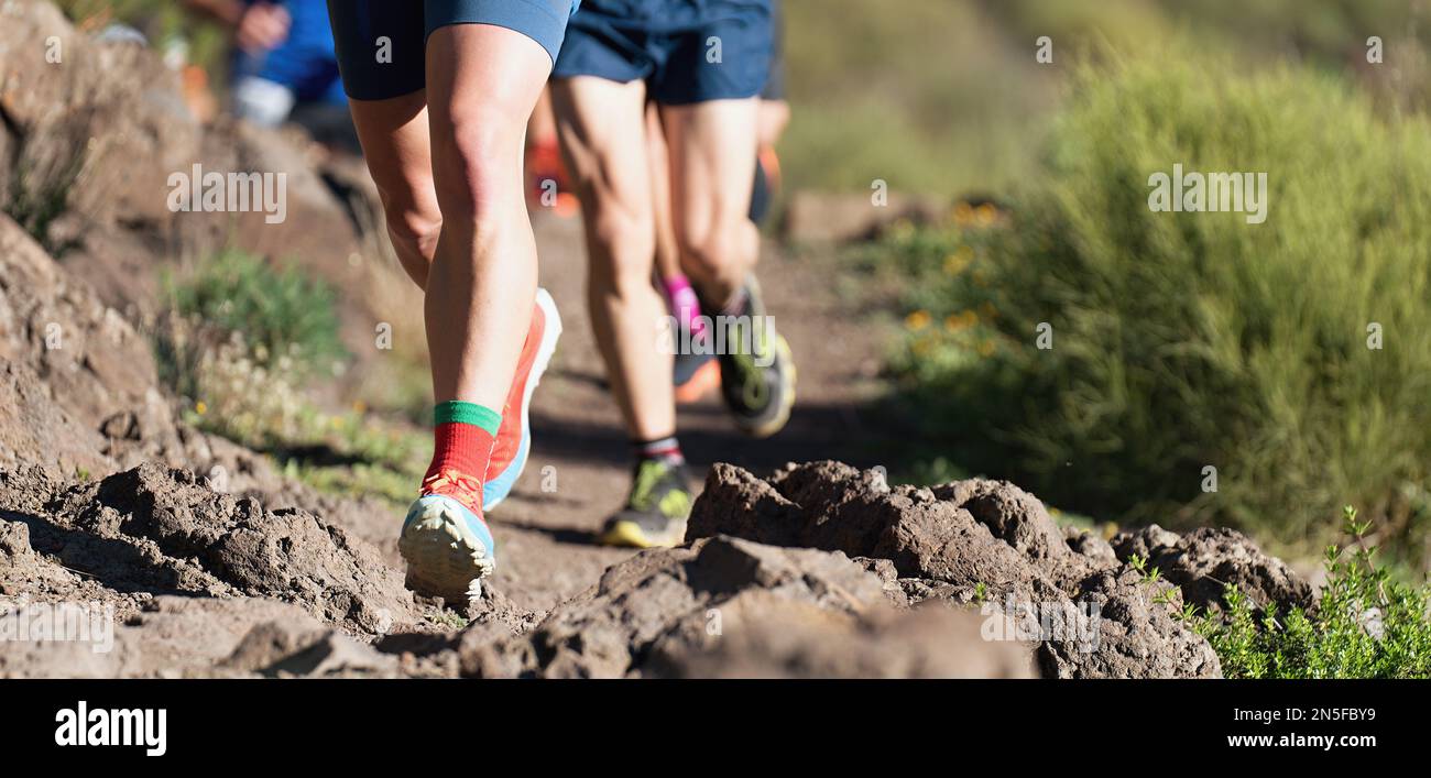 Group of young adults competition and running together through trails ...