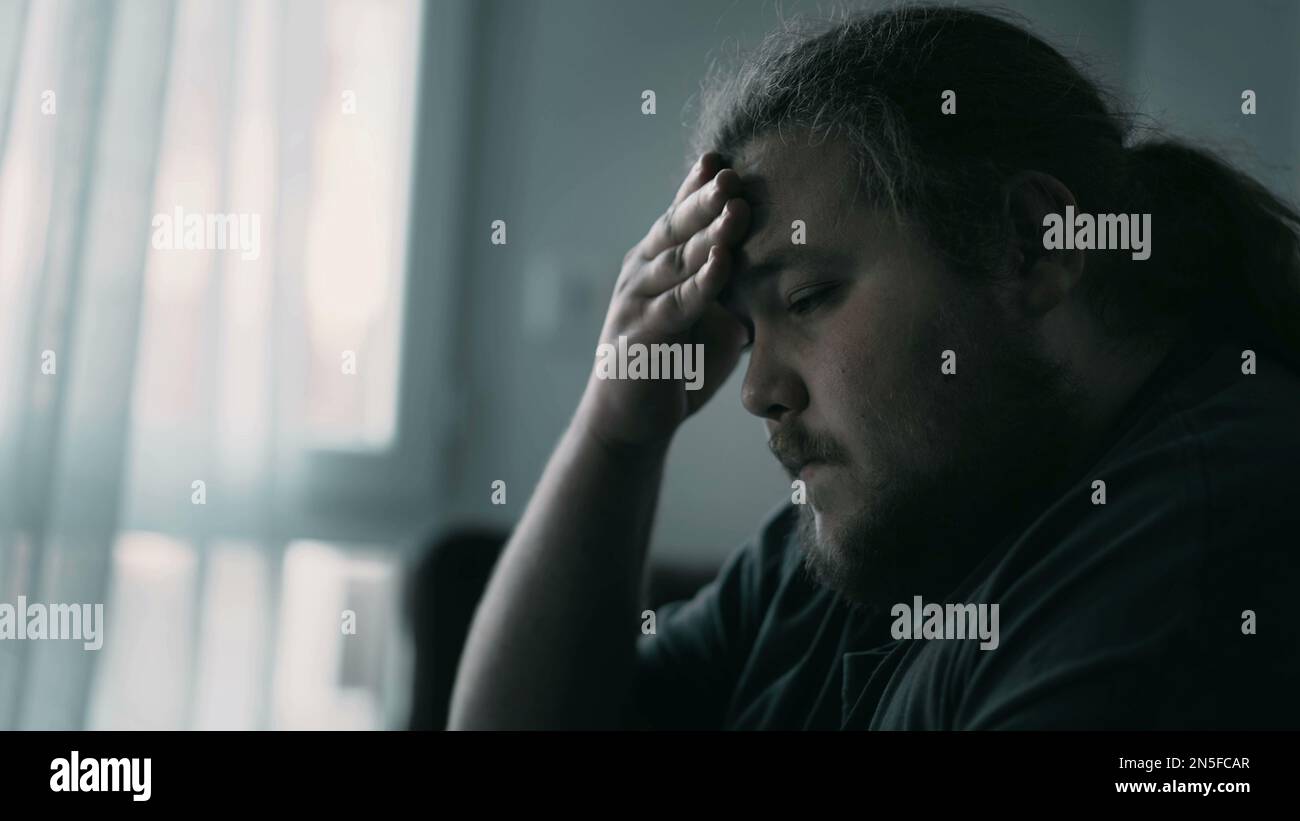Depressed man sitting on couch. Sad unhappy person suffering from ...