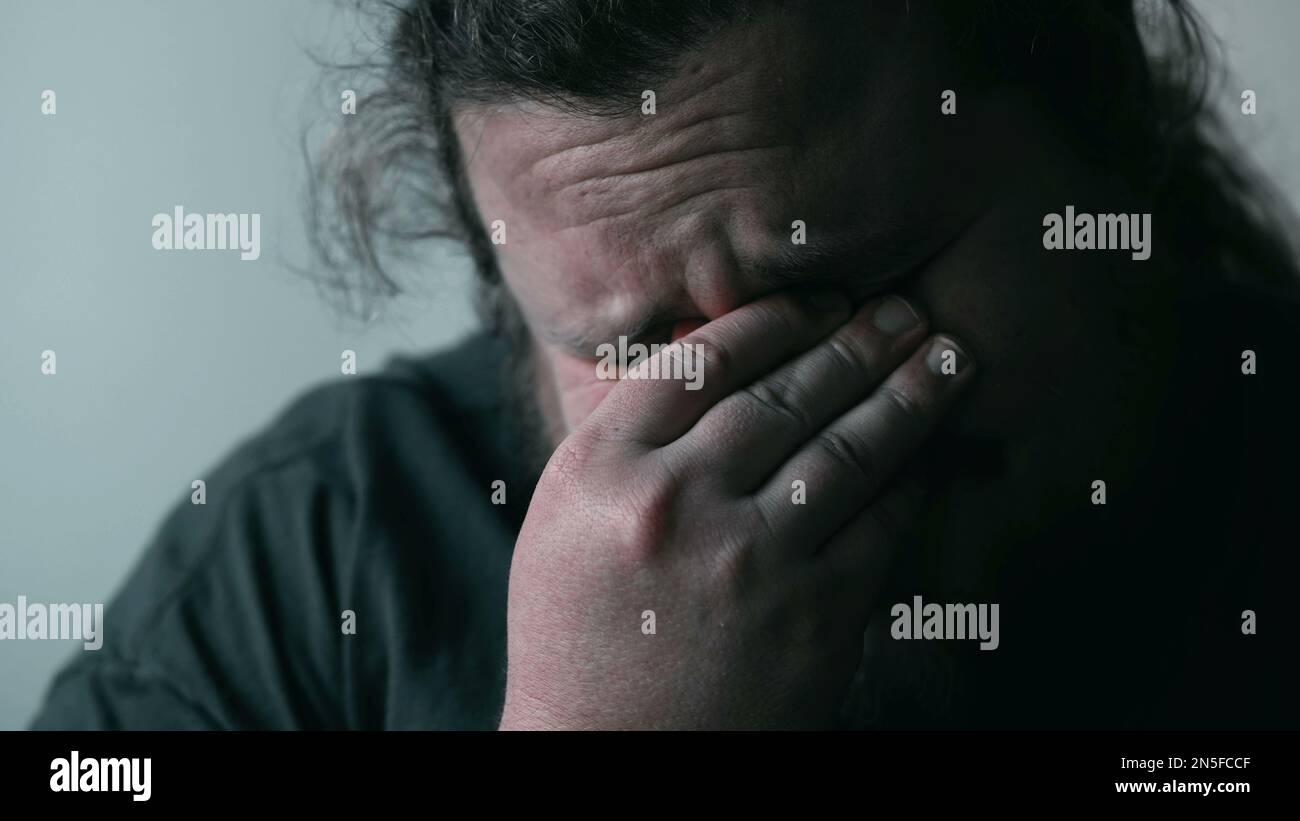 Desperate man crying in despair covering face in shame and regret ...