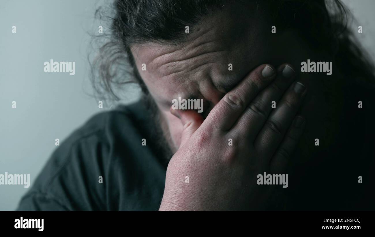 Desperate man crying in despair covering face in shame and regret ...