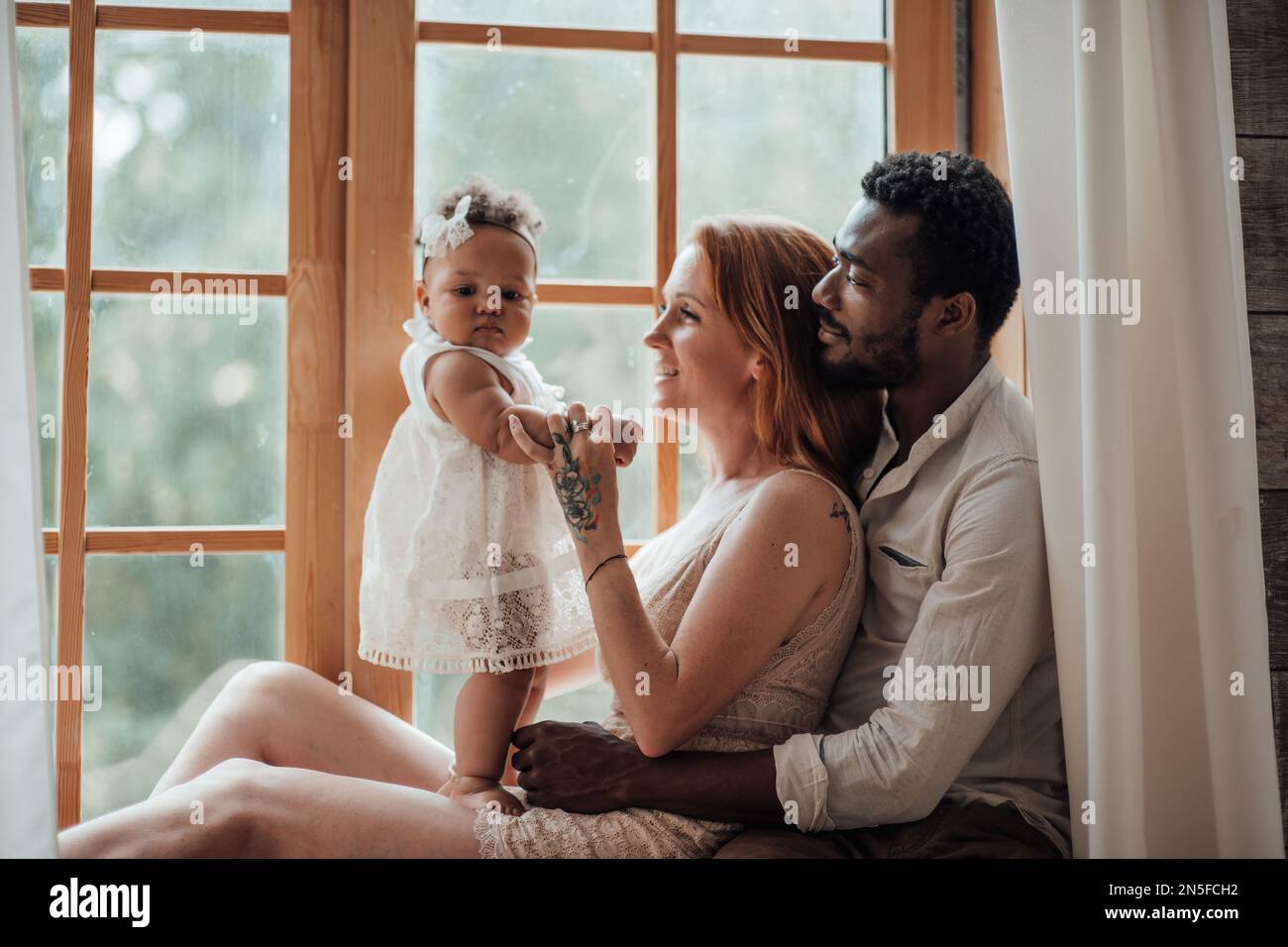 Mixed race family with dark skinned infant daughter spend time together ...