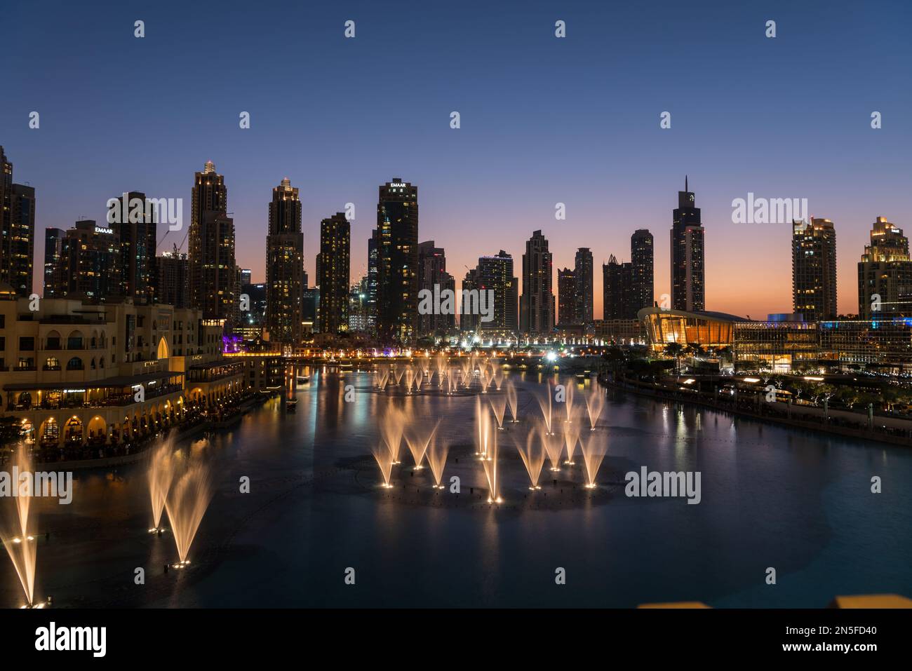Dubai singing fountains at night lake view between skyscrapers. City ...
