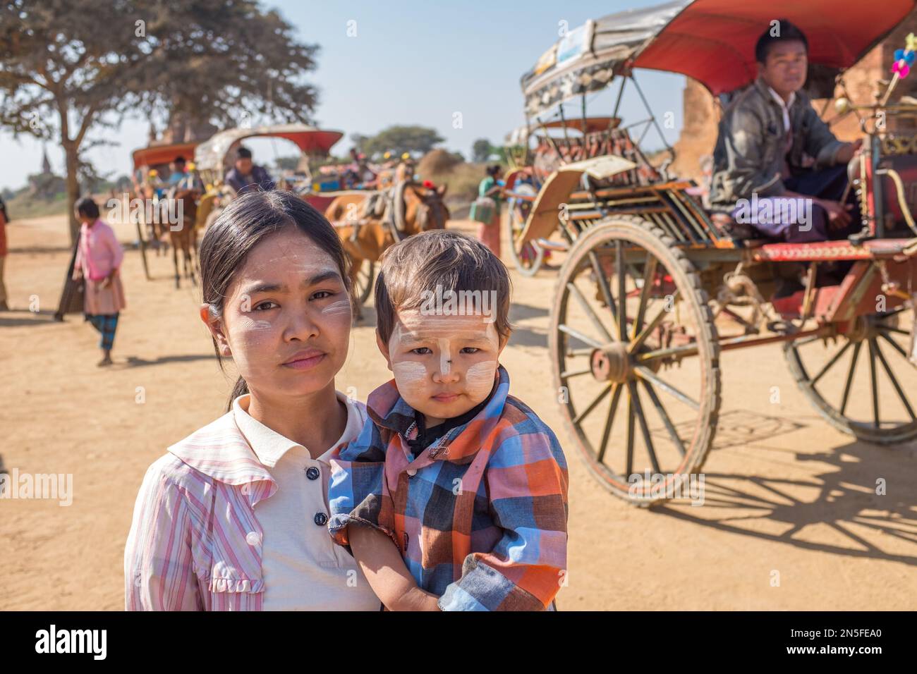 Young Burmese woman with child in Bagan. Facial painting with white ...