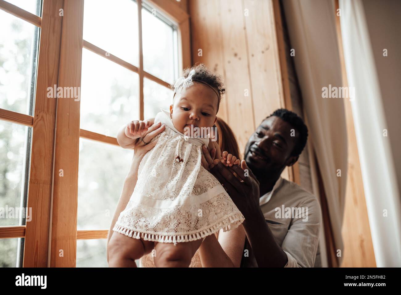 Mixed race family with dark skinned infant daughter spend time together ...