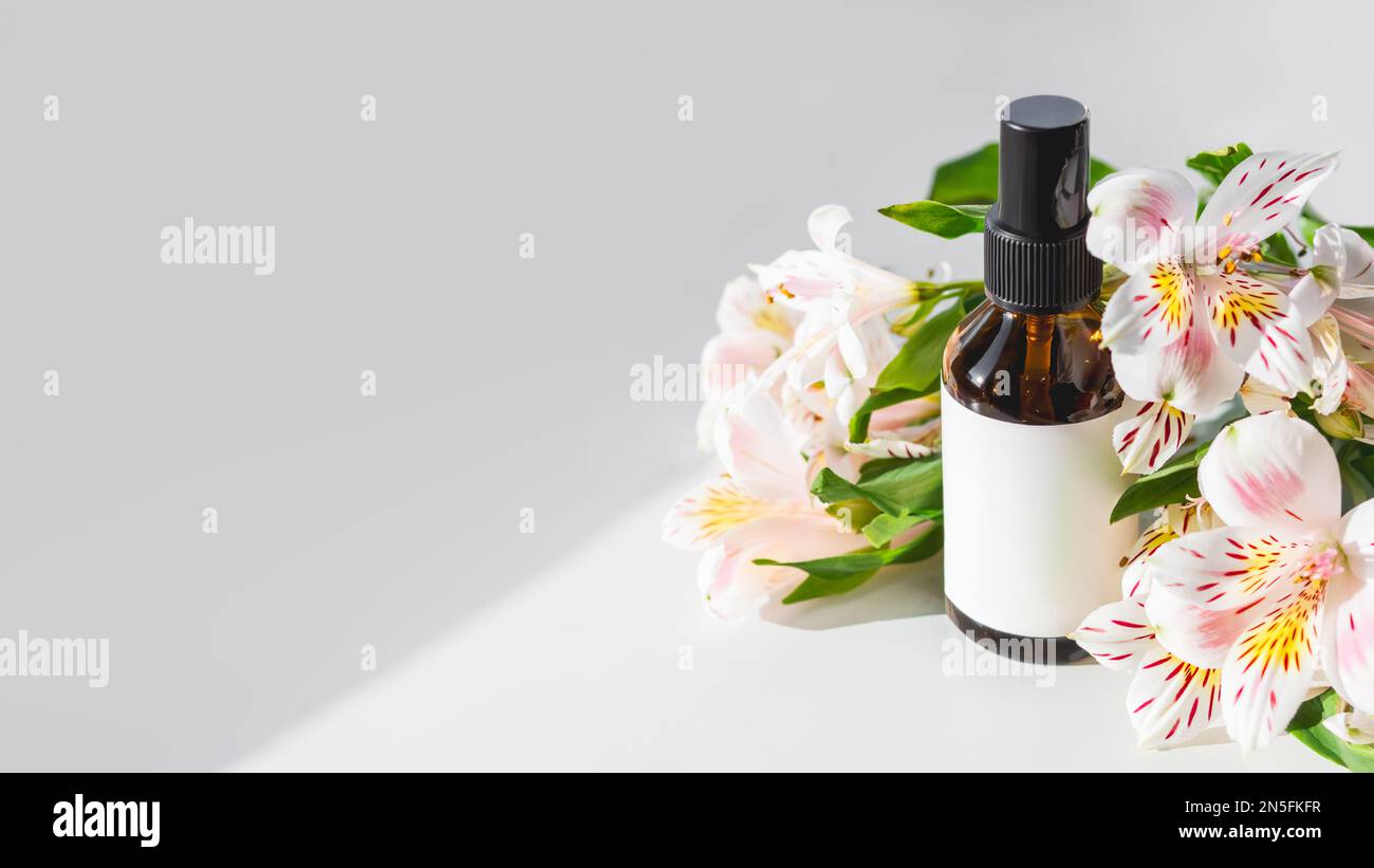 Apothecary cosmetic. Flower petals and brown glass bottle of essential ...