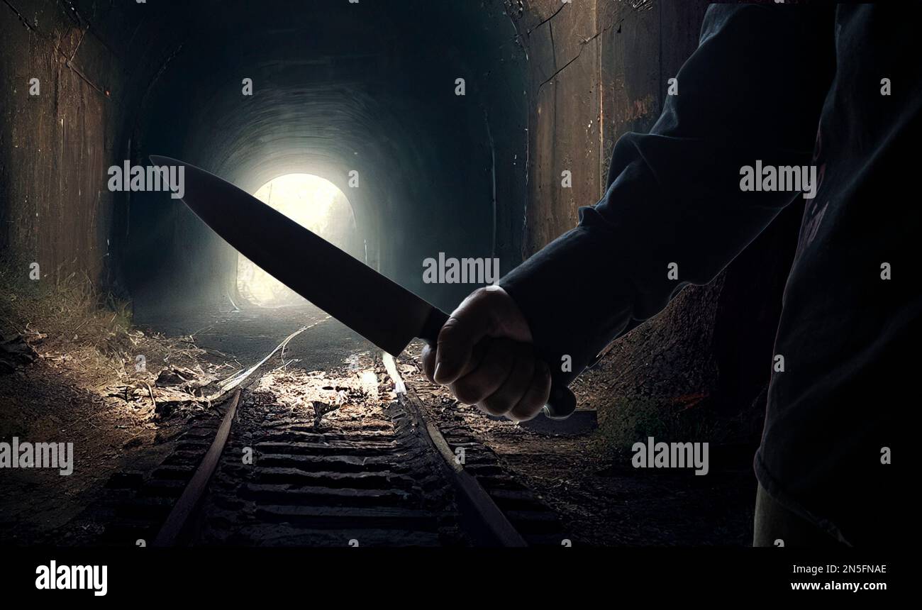 A person holding a knife inside a tunnel.Murder crime concept Stock ...