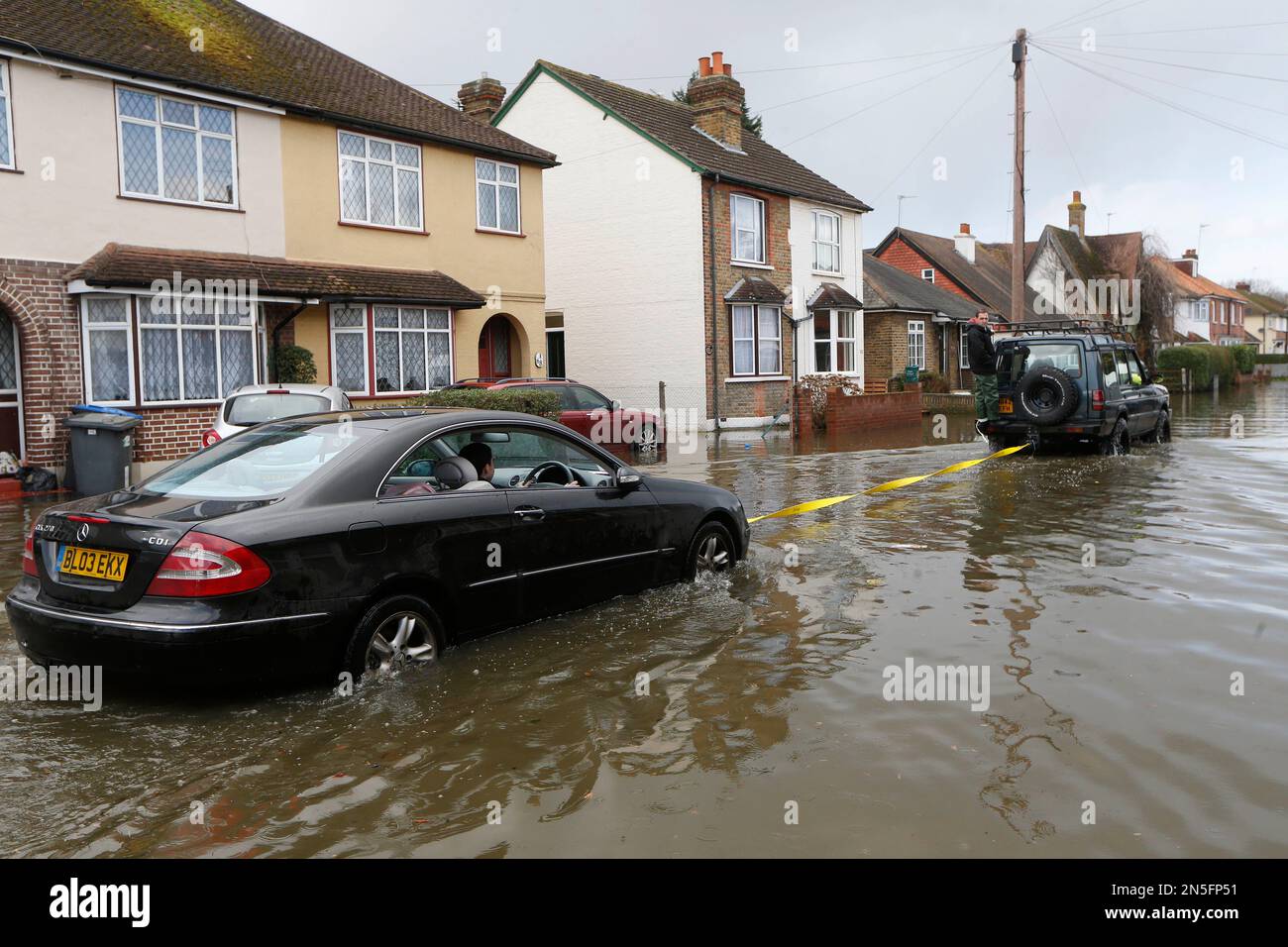 A car is towed through a flooded street in Egham, England, Thursday ...