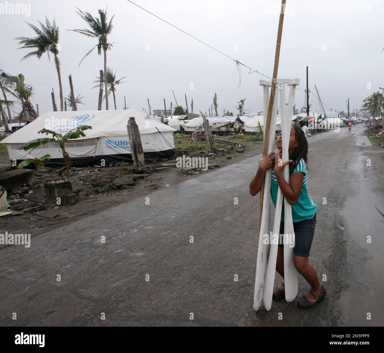 A typhoon survivor carries oars which were donated by the charitable ...