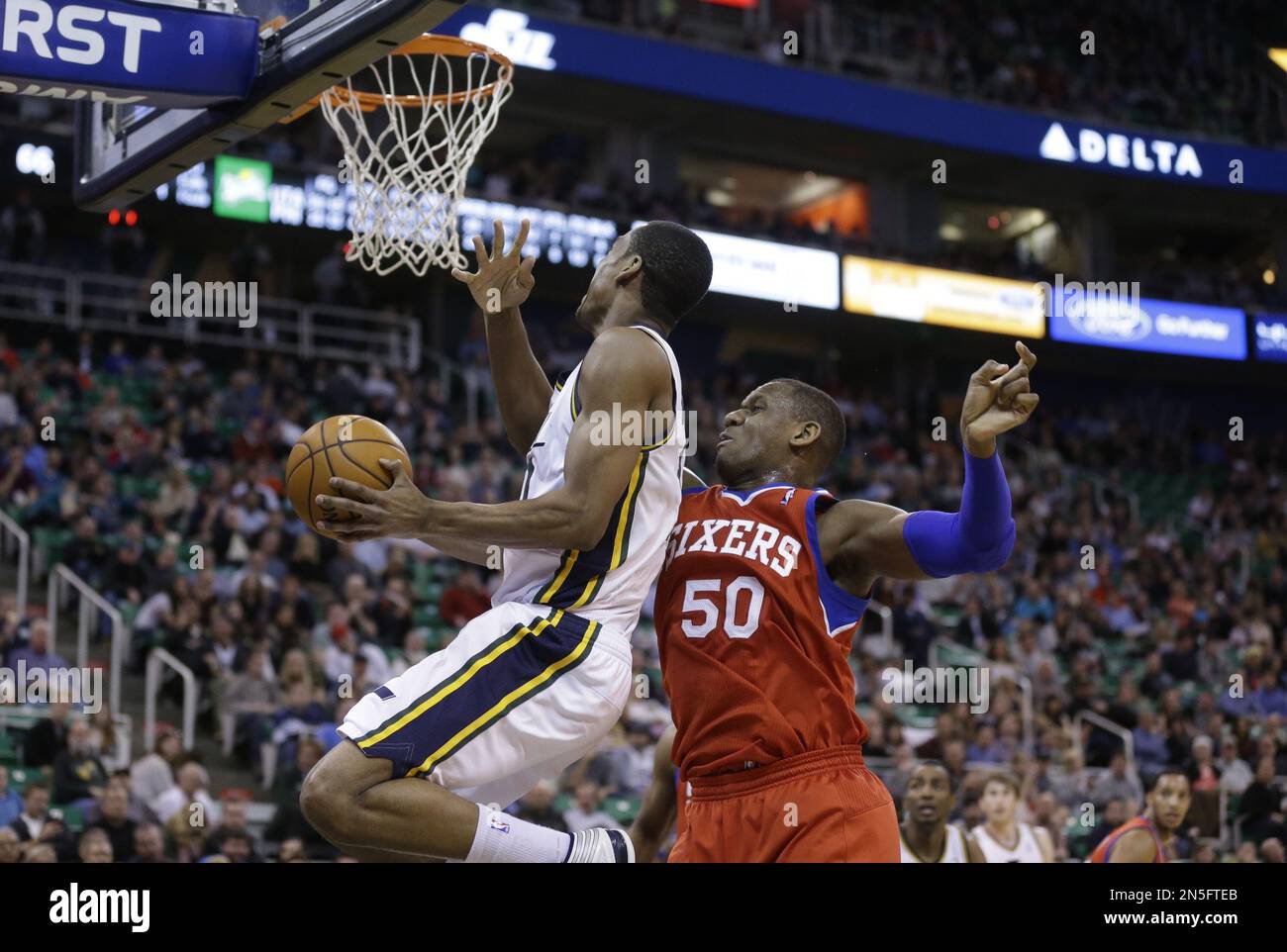 Utah Jazz's Alec Burks, left, lays the ball up as Philadelphia 76ers ...