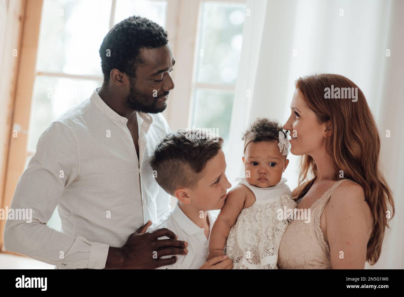 Mixed race family with white son and infant swarthy daughter spend time ...