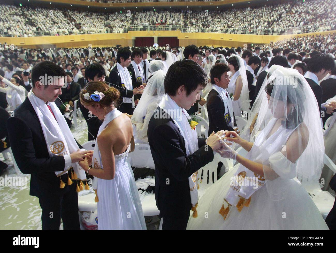 Couples from around the world exchange their rings in a mass wedding ...