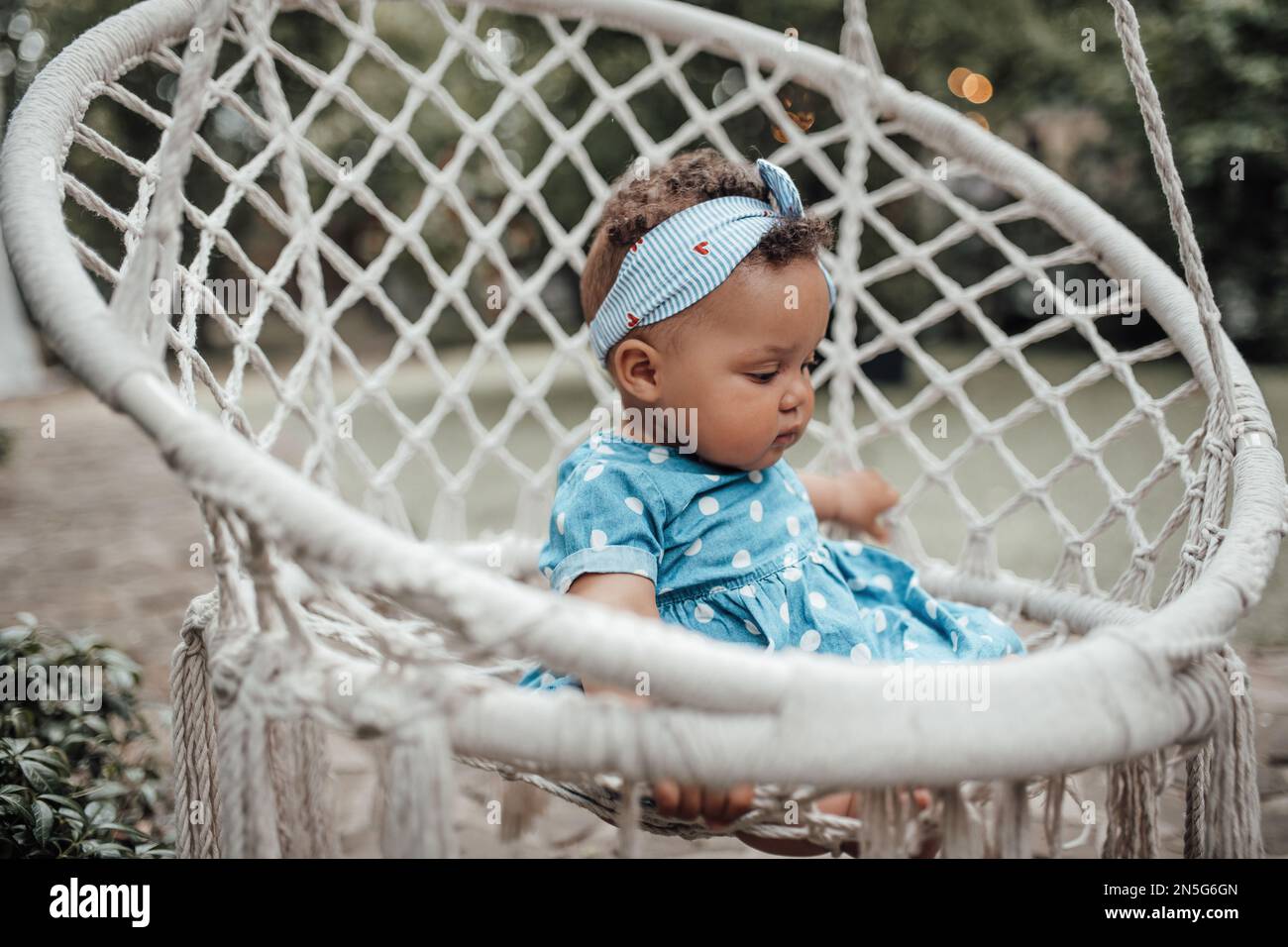 Swarthy little girl in blue polka dot dress has positive emotion ...
