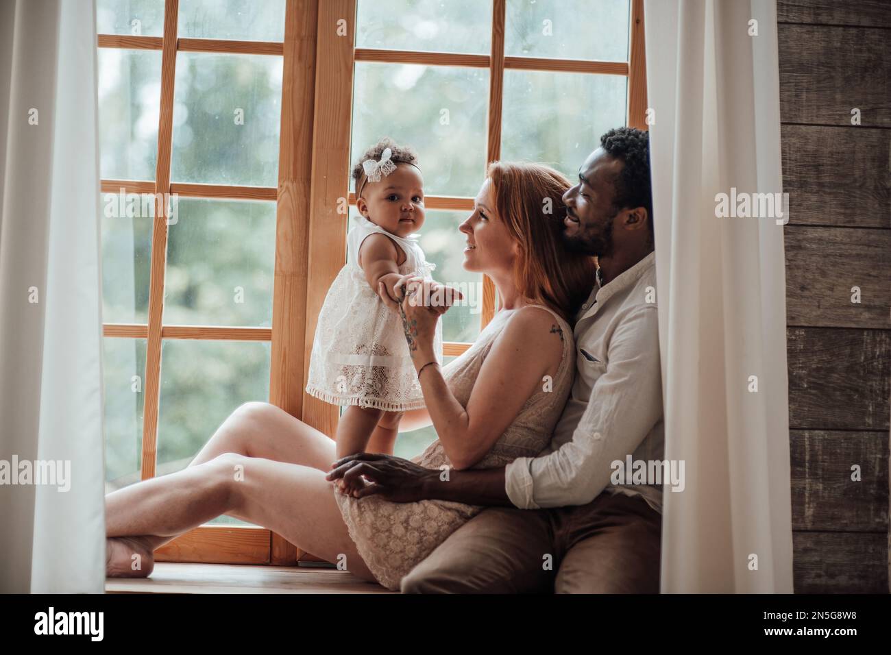Mixed race family with dark skinned infant daughter spend time together ...