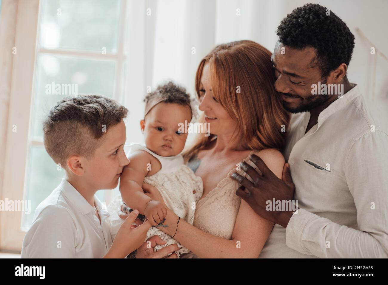 Mixed race family with white son and infant swarthy daughter spend time ...