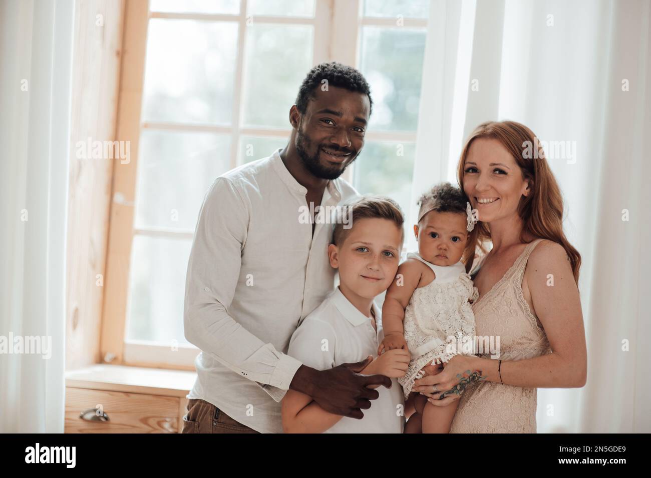 Mixed race family with white son and infant swarthy daughter spend time ...