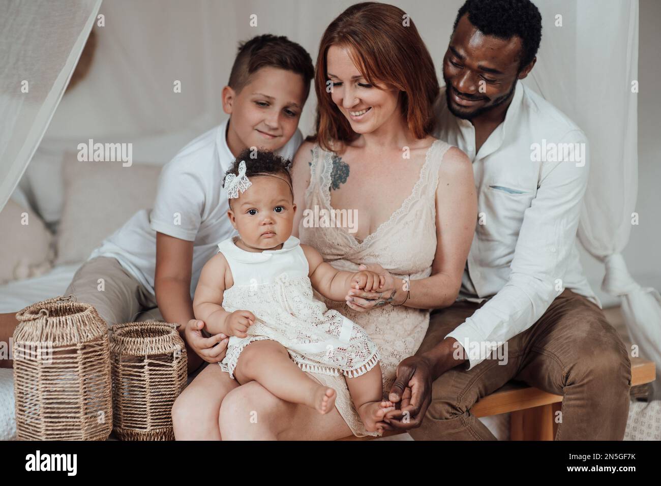 Mixed race family with white son and infant swarthy daughter spend time ...