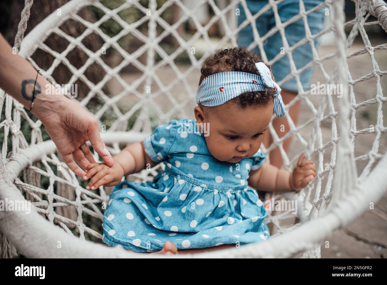 Swarthy little girl in blue polka dot dress has positive emotion ...