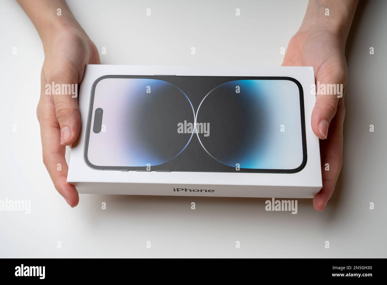 A girl holds the latest iPhone 14 Pro Max, Space Black. Apple's latest ...