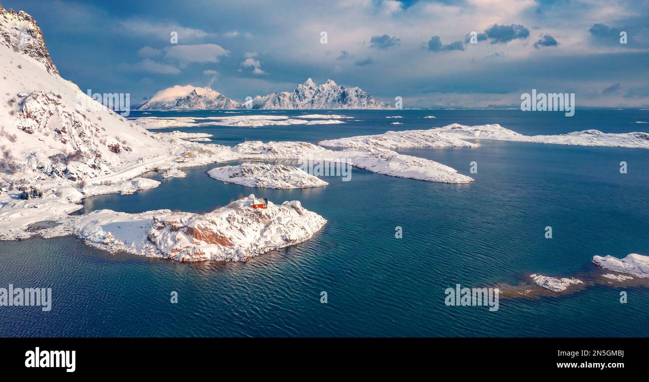 Red wooden house on the cliff. Fabulous winter view from flying drone ...