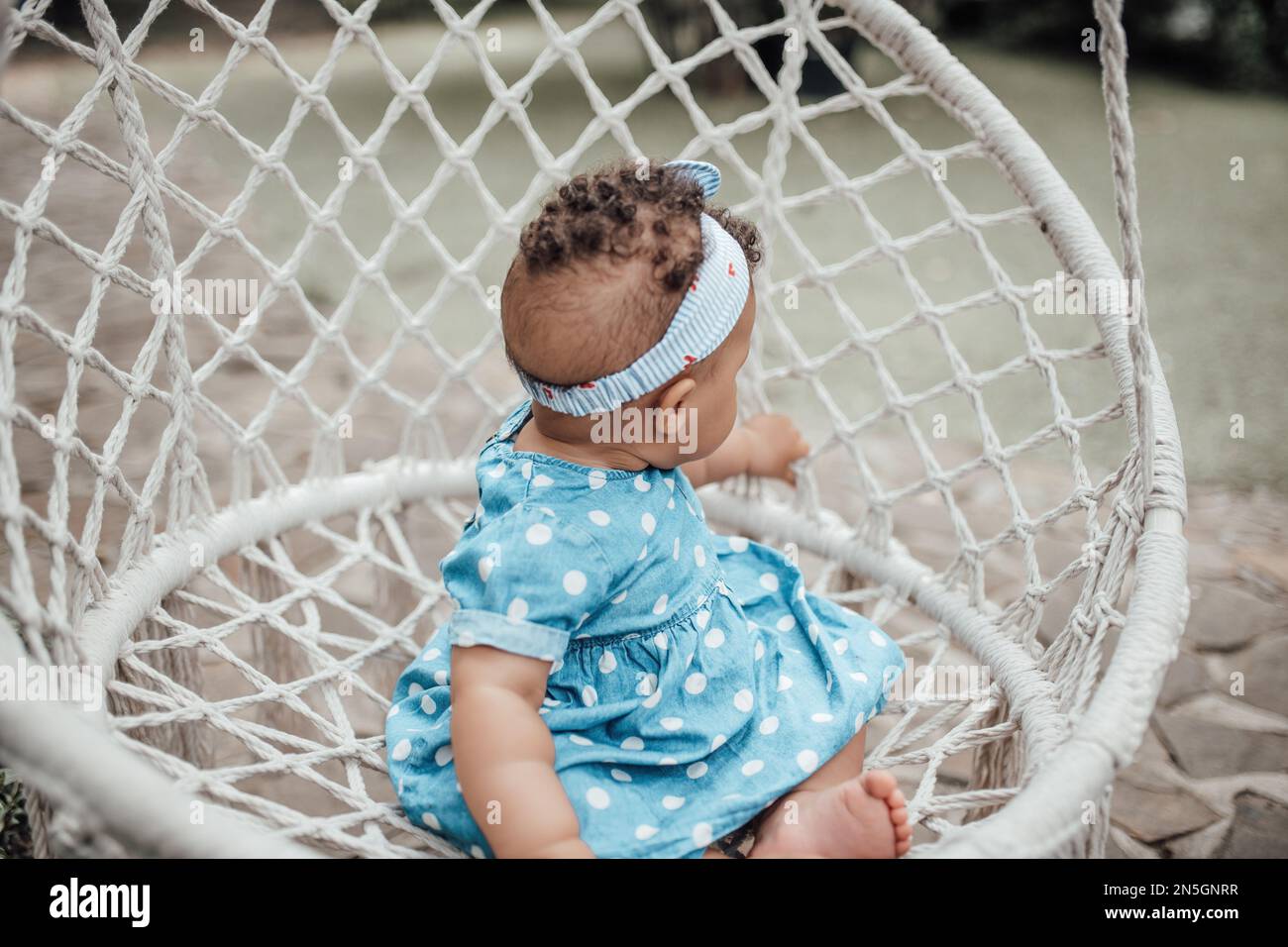 Swarthy little girl in blue polka dot dress has positive emotion ...