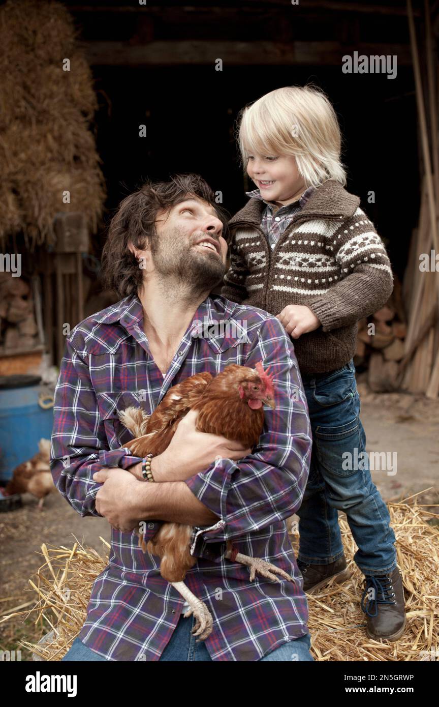 Father holding hen and looking at his son, Bavaria, Germany Stock Photo ...