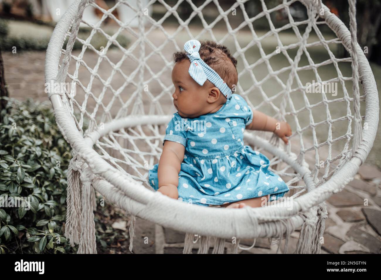 Swarthy little girl in blue polka dot dress has positive emotion ...