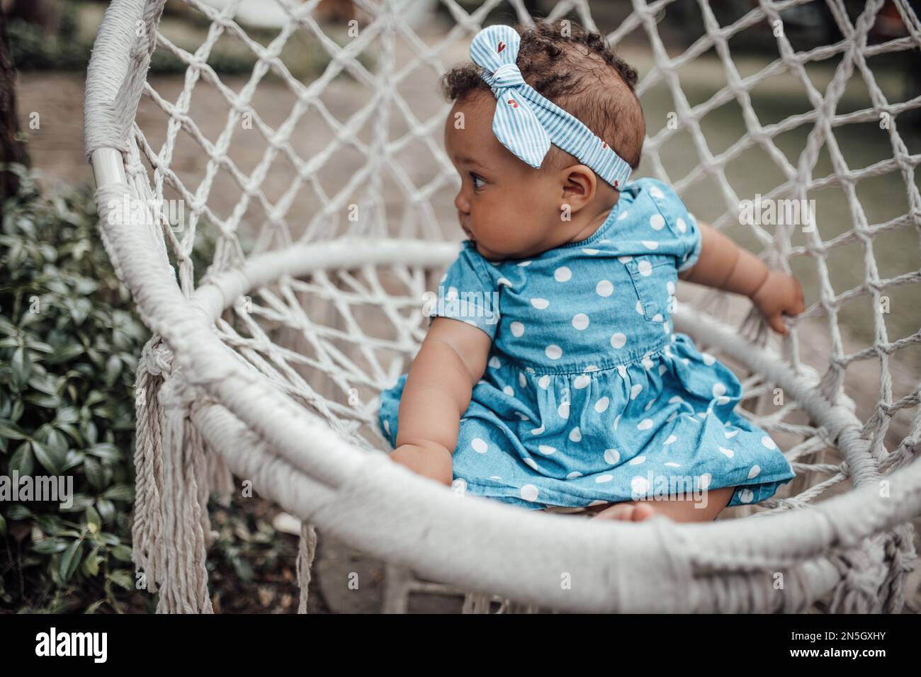 Swarthy little girl in blue polka dot dress has positive emotion ...