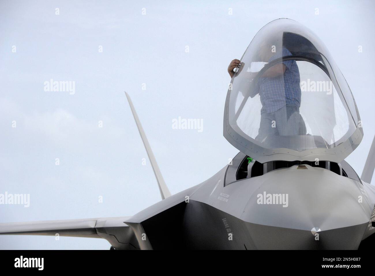 A man cleans the canopy of a F-35 Lightning II fighter jet on display ...
