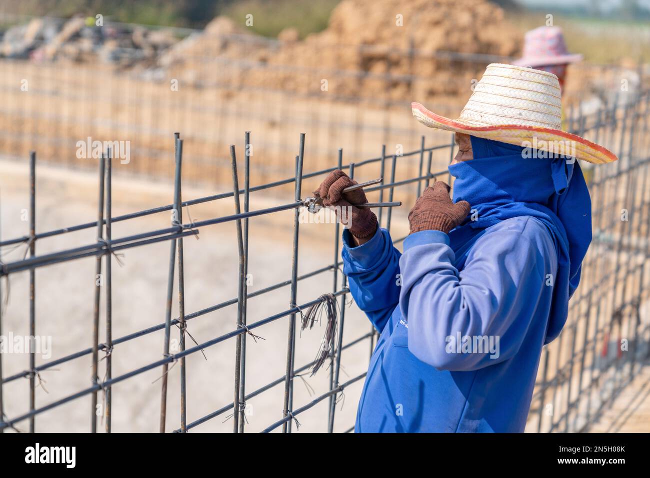 Worker bundle wire steel rod for construction job Stock Photo - Alamy