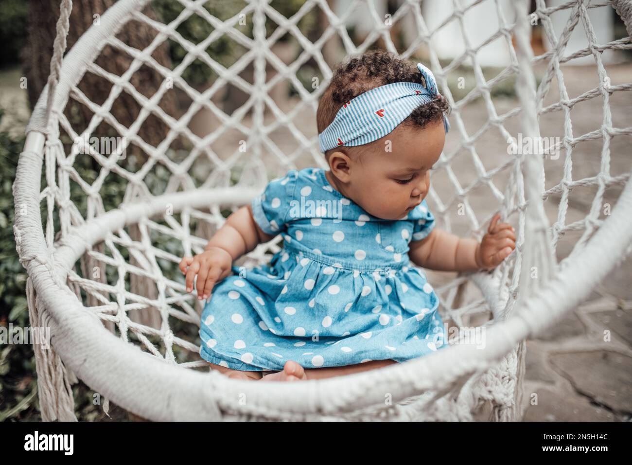 Swarthy little girl in blue polka dot dress has positive emotion ...