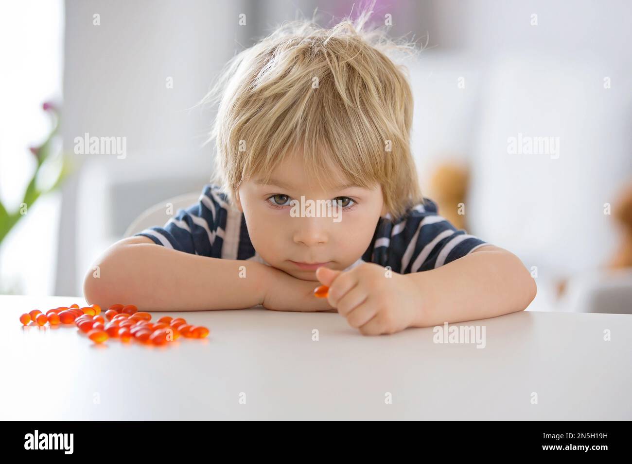 Cute little child, toddler boy, eating alfa omega 3 child supplement ...
