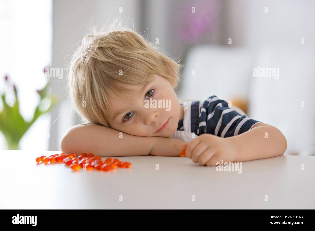 Cute little child, toddler boy, eating alfa omega 3 child supplement ...