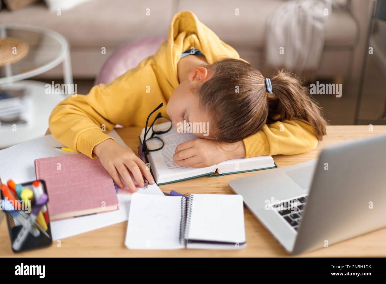 Top view of school girl is sleeping on open book while doing homework ...