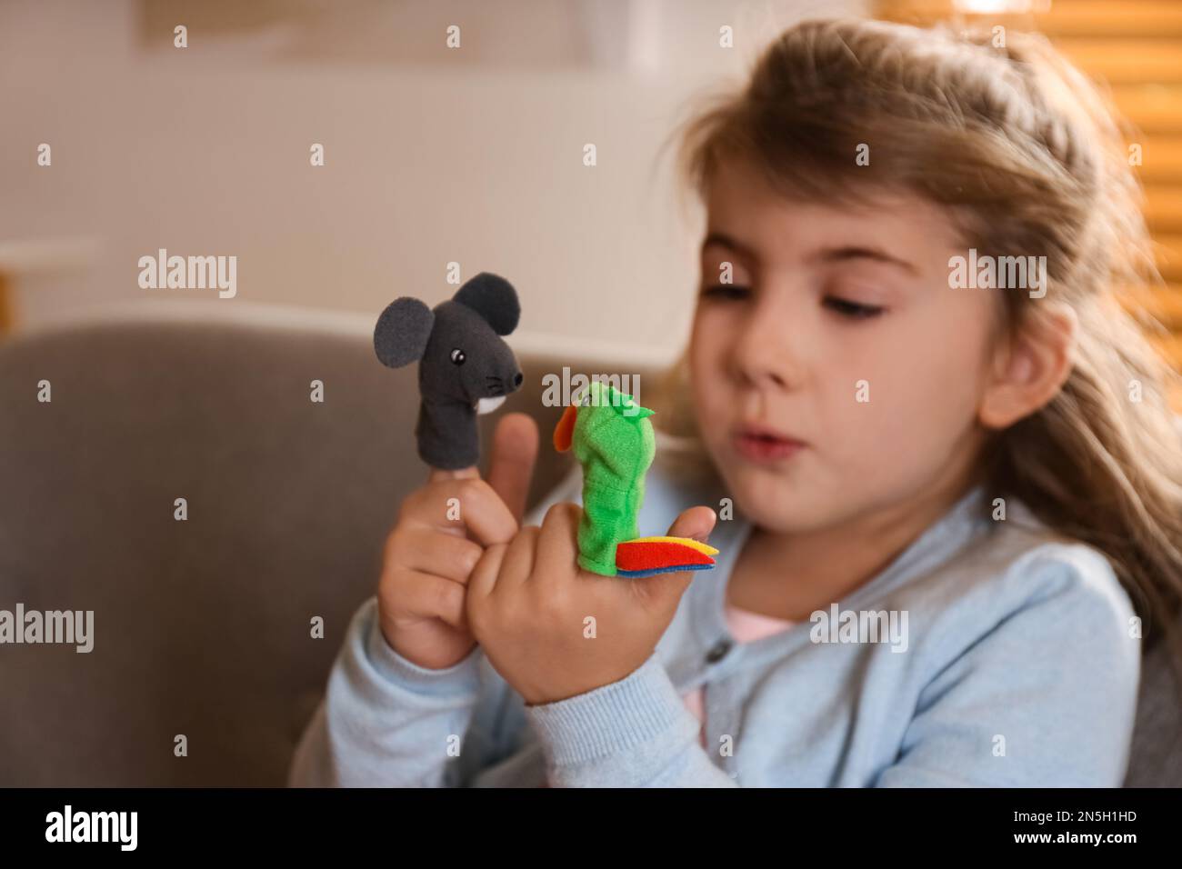 Cute little girl with finger dolls for puppet show at home Stock Photo ...