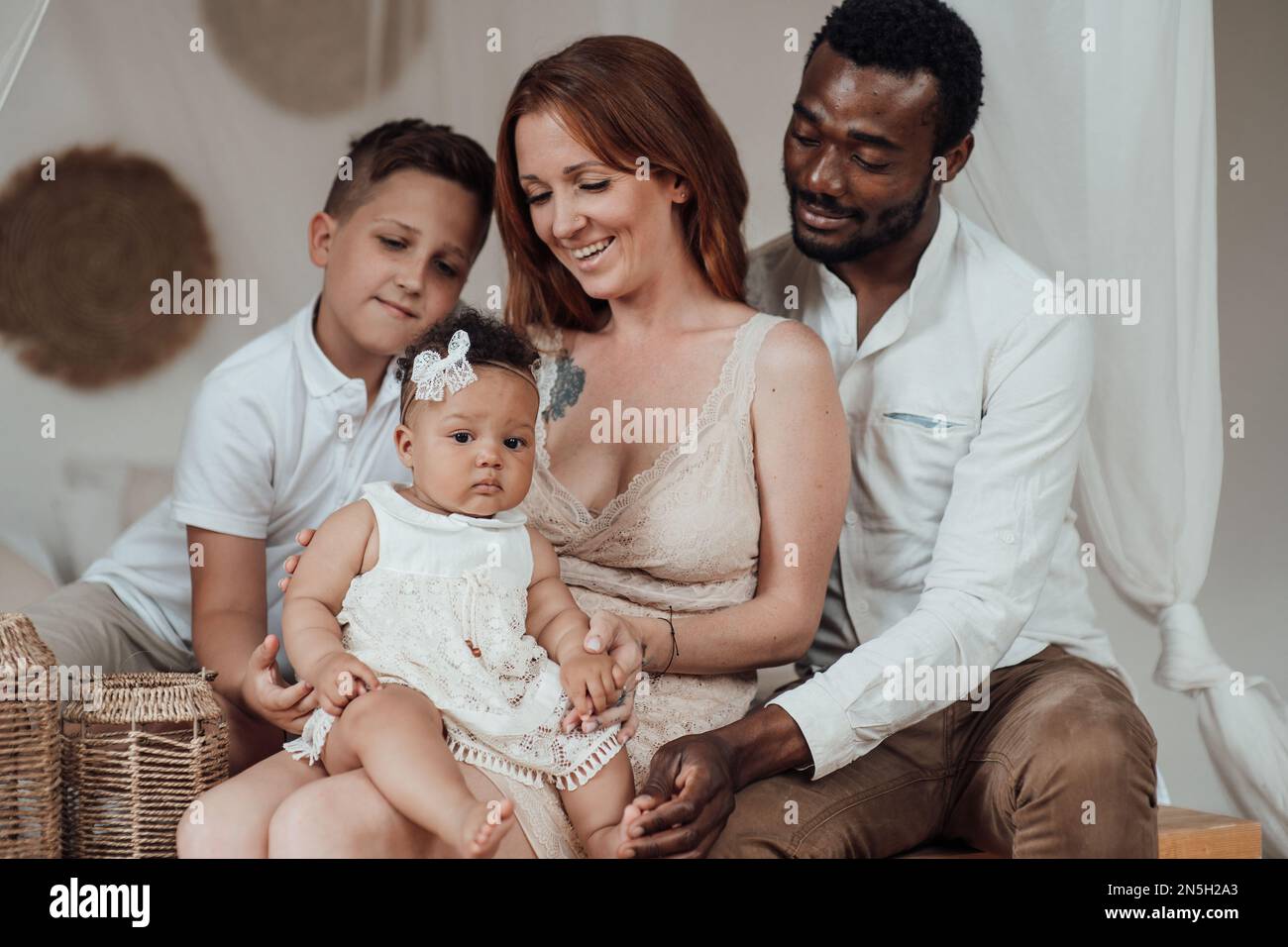 Mixed race family with white son and infant swarthy daughter spend time ...