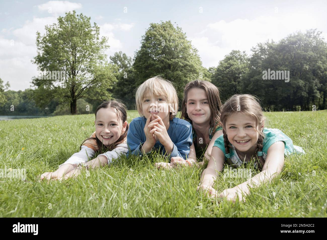 Four friends lying on grass hi-res stock photography and images - Alamy