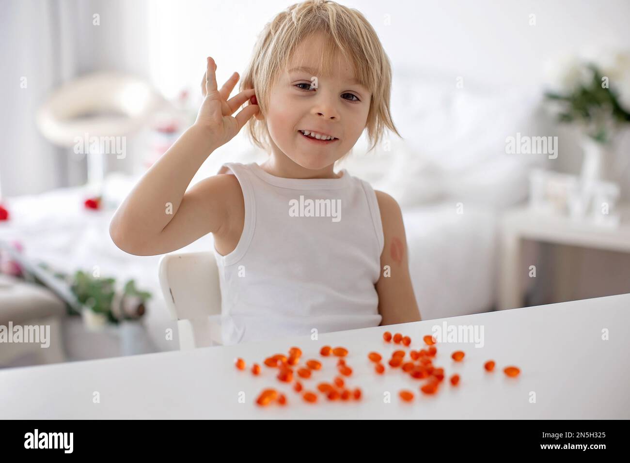 Cute little child, toddler boy, eating alfa omega 3 child suplement ...