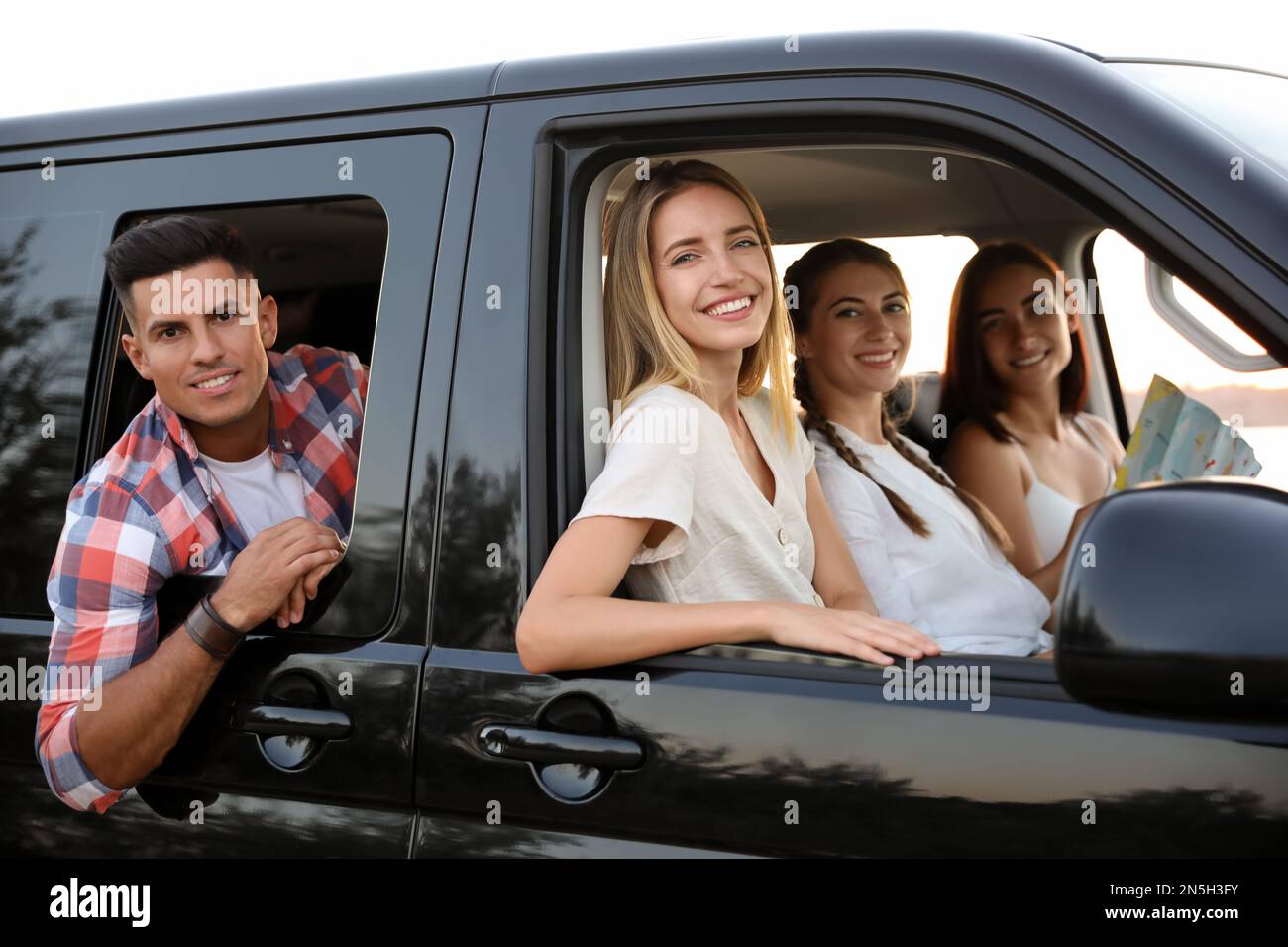 Happy friends together in car on road trip Stock Photo - Alamy