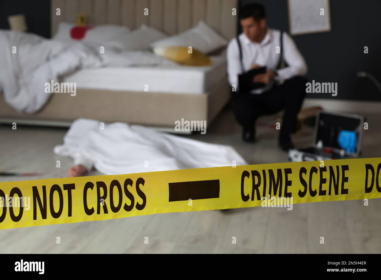 Investigator working at crime scene with dead body, focus on yellow ...