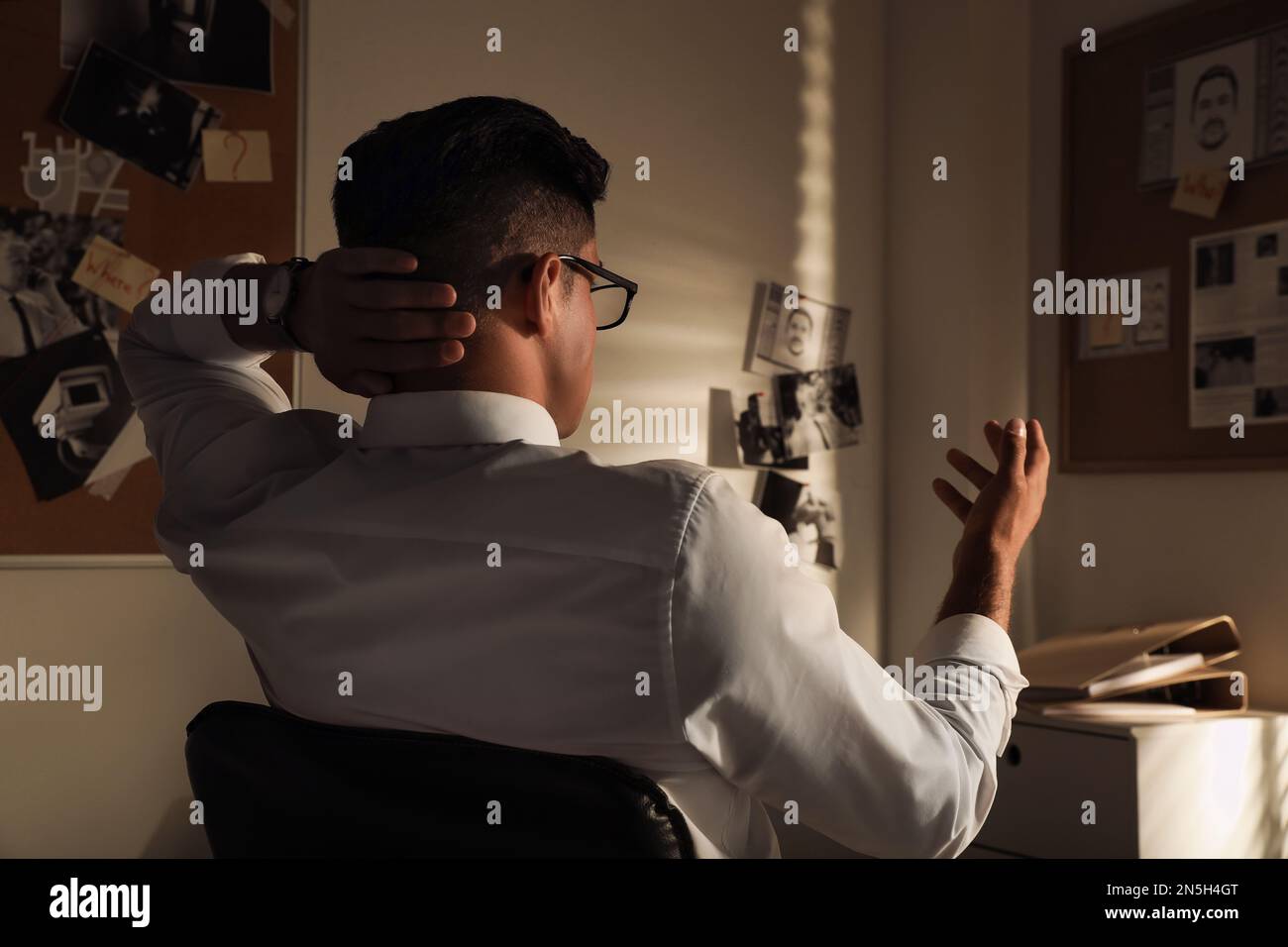 Detective looking at evidence board in office Stock Photo - Alamy