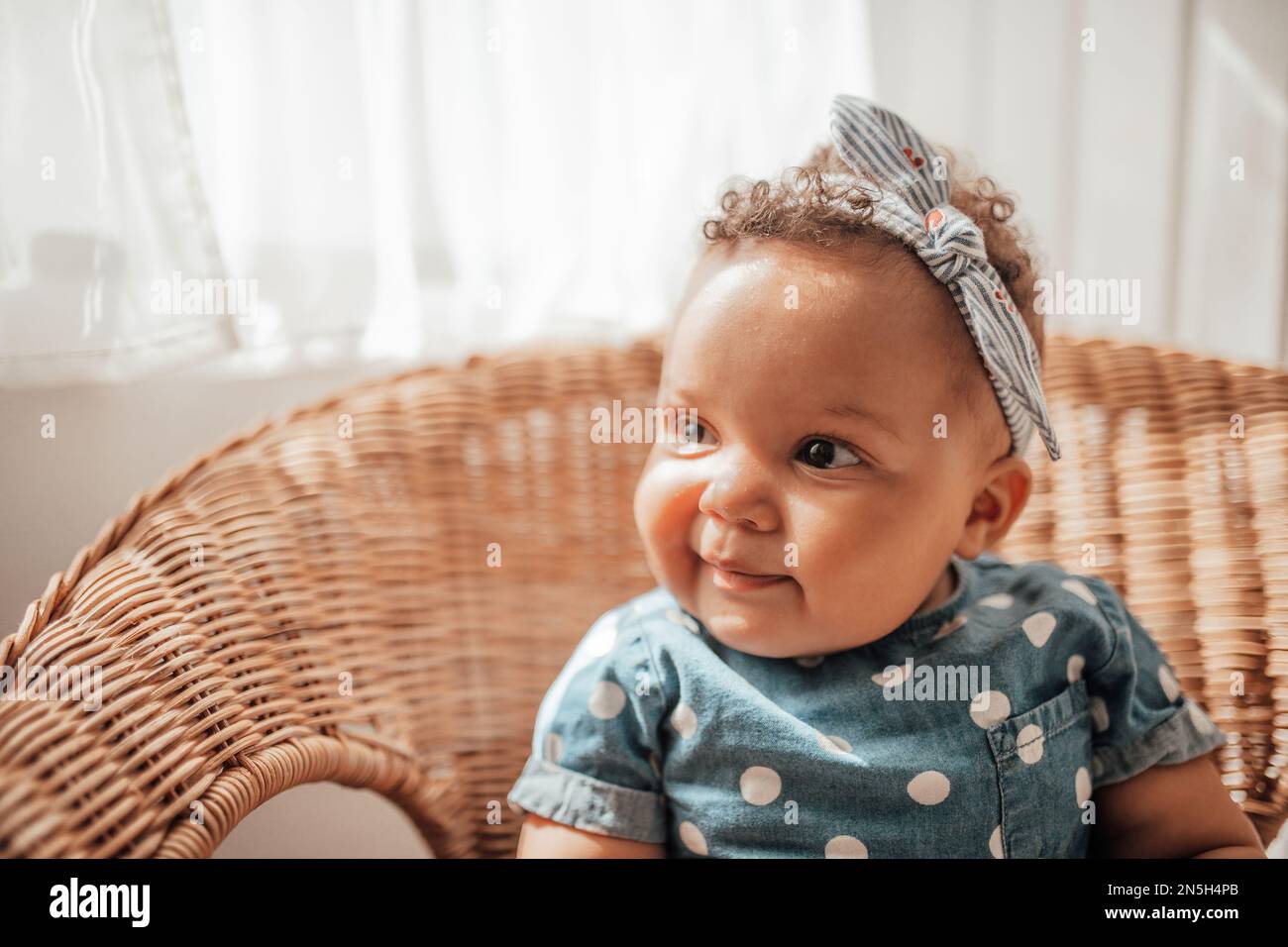 Swarthy little girl in blue polka dot dress has positive emotion ...