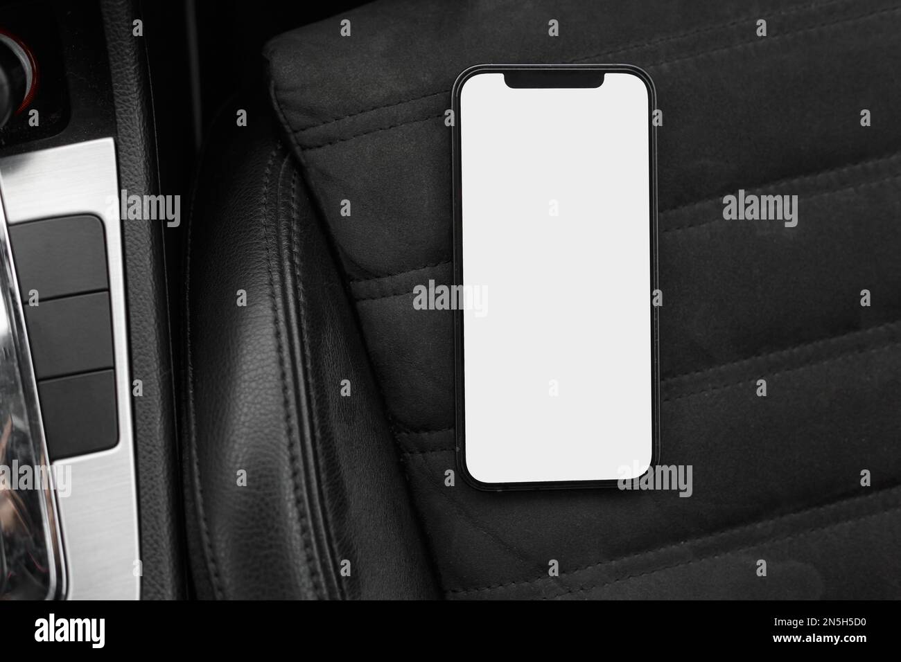 Smart phone with blank white screen on leather car seat in vehicle ...
