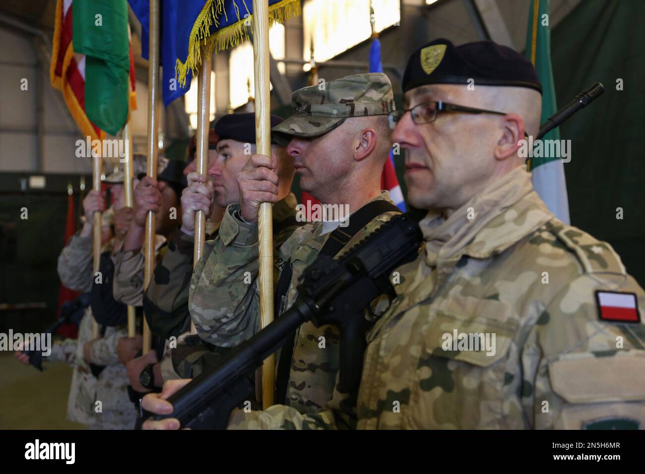 International Security Assistance Force (ISAF) forces hold flags during ...