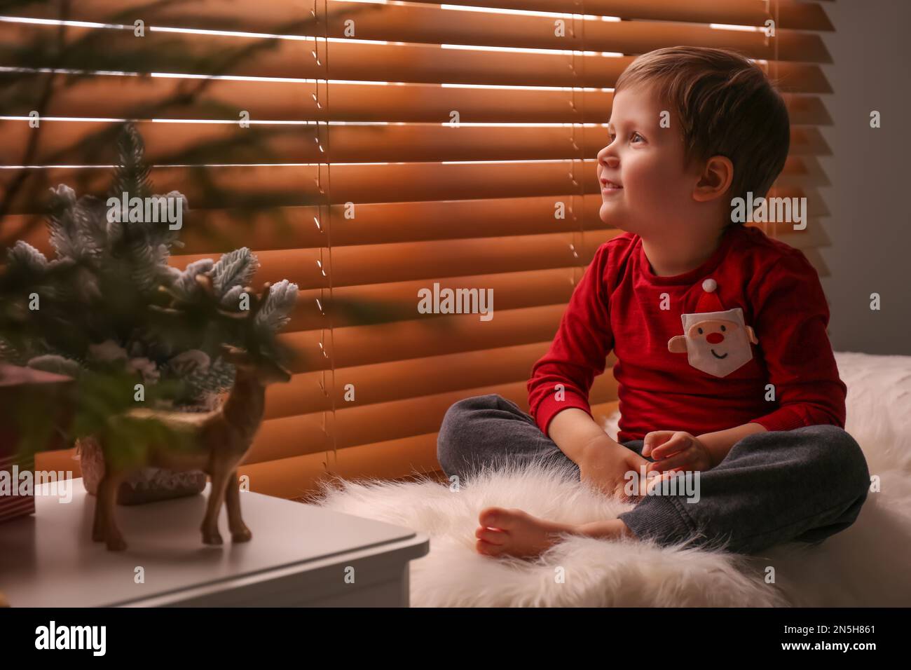 Cute little boy near window at home. Christmas atmosphere Stock Photo ...