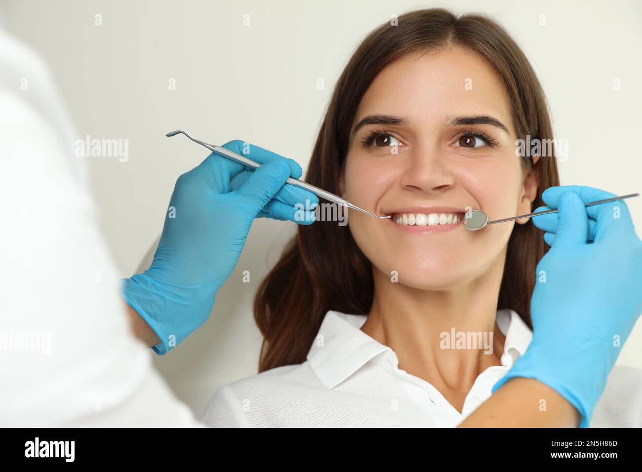 Dentist examining young patient's teeth hi-res stock photography and ...