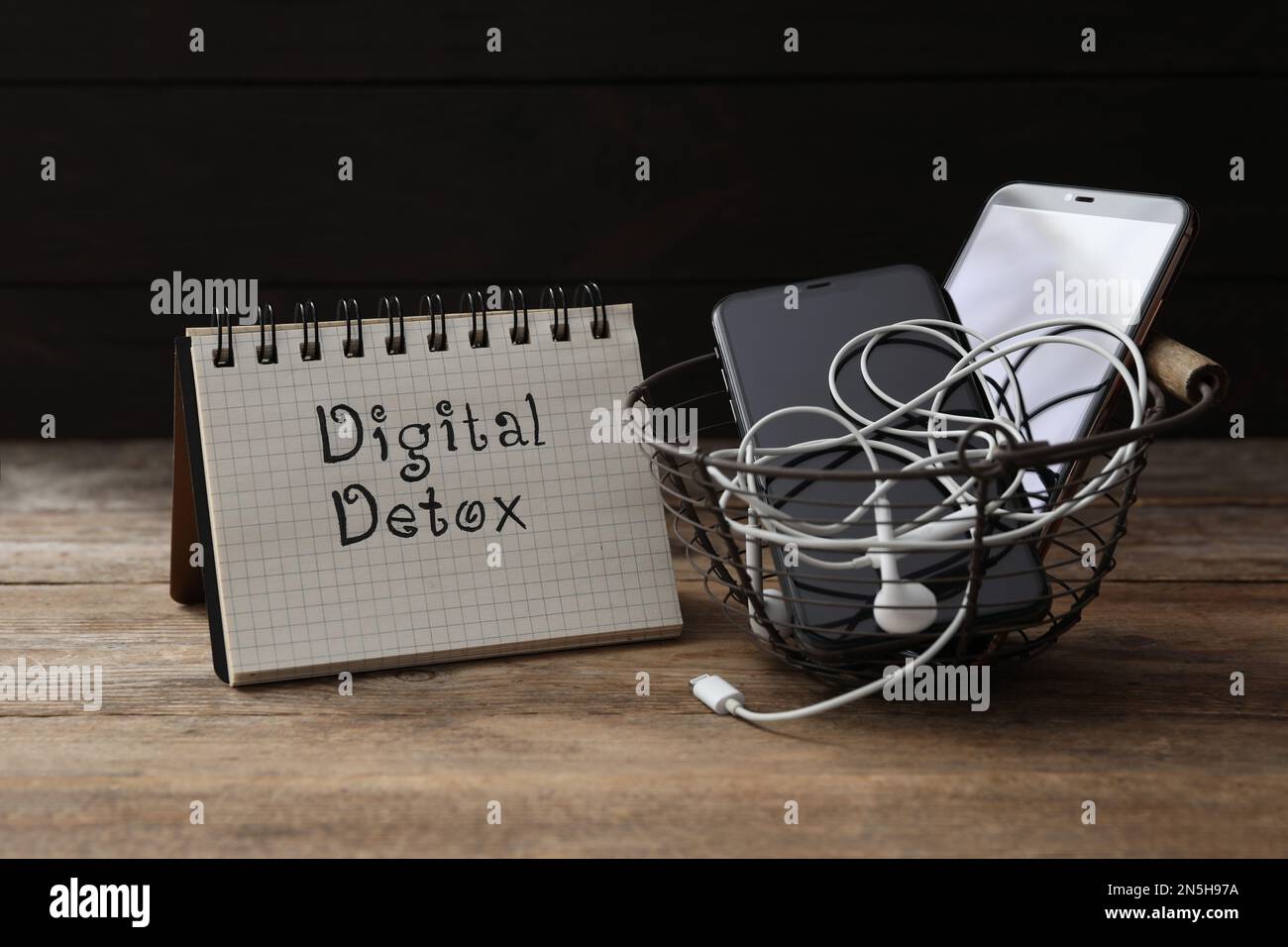 Trash bin with different gadgets and words DIGITAL DETOX on wooden ...